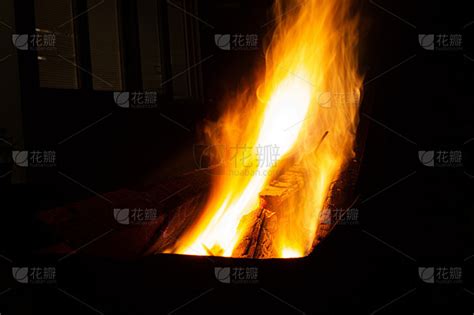 晚上炉火在烤架上燃烧。明亮的火木。夜晚的火焰