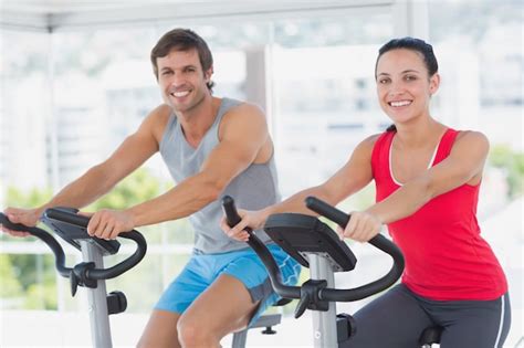 Premium Photo Smiling Young Couple Working Out At Spinning Class