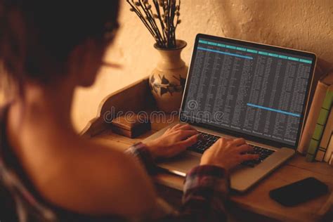 Back View Of Caucasian Female Programmer Siting At Desk Using Laptop