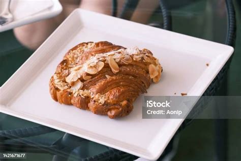 선택적 초점 호텔 아침 식사 베이커리와 패스트리 바의 흰색 접시 위에 아몬드 슬라이스가있는 신선한 크로와상 전통적인 프렌치