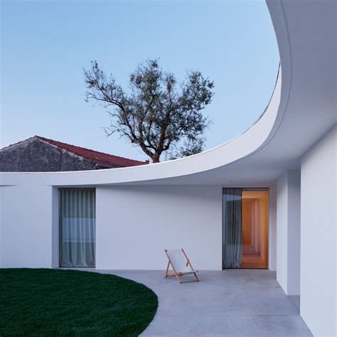 Curving Roof And Stone Walls Create Seclusion For House By Noarq