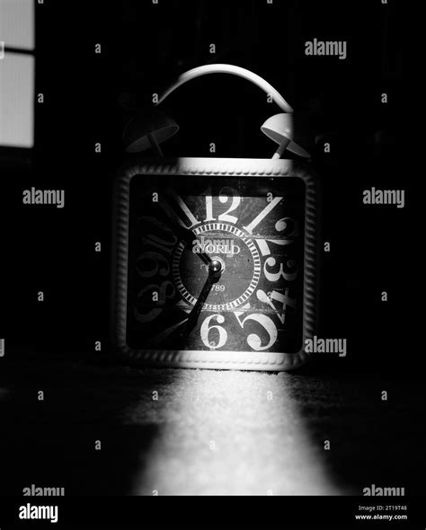 Black And White Photograph Of An Analog Clock In A Dark Room With