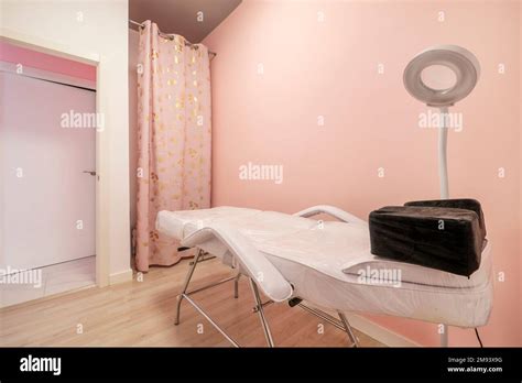 Massage Booth With A Folding Table In A Beauty Salon With Pink Walls A White Circular Lampshade