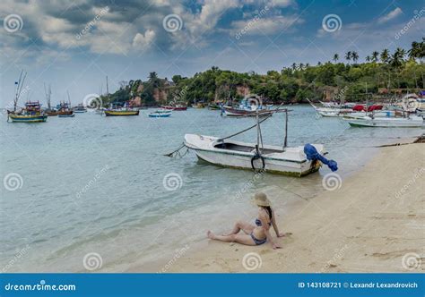 Beautiful Pretty Woman In The Hat And Bikini Sitting On The Beach At