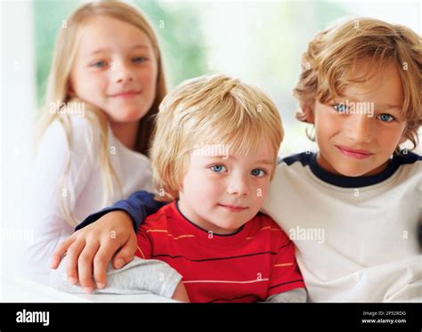 Two Cute Brothers And A Sister Sitting Together Portrait Of Two Cute
