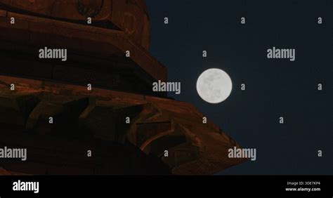 Full Moon Rising Behind Illuminated Mughal Dome Of Red Fort At Blue