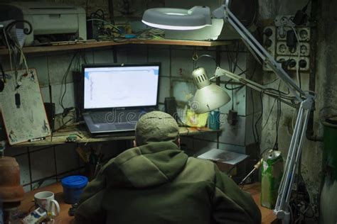 Hacker Is Sitting At A Laptop Anonymous Person On The Internet Stock
