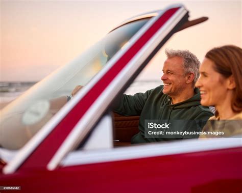 Retired Senior Couple On Vacation Sitting In Classic Sports Car At