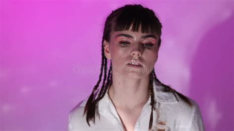 A Female Model With Braided Hair Turns Her Head And Looks At The Camera