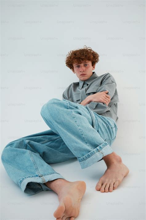 다리를 꼬고 땅에 앉아 있는 어린 소년 사진 Unsplash의 슬픔 이미지
