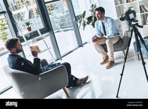 Business Interview Two Young Men In Smart Casual Wear Talking While Business Interview Two Young Men In Smart Casual Wear Talking While