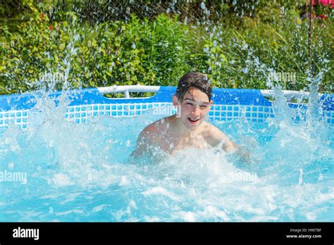 Cute Teen Boy Enjoying Summer Splashing Water In A Swimming Pool Stock