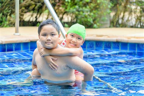 Brother Holding Sister On His Back In Swimming Pool 23310860 Stock