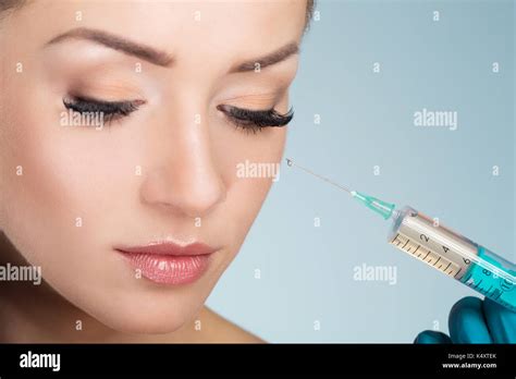 Portrait Of Beautiful Woman Face And Syringe With Medication Stock