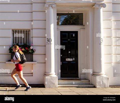Woman Runner With Red Shorts And Backpack In Front Of White Pillared
