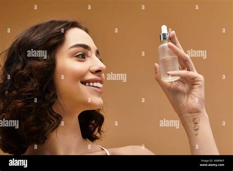 A Young Woman With Braces Happily Demonstrates Her Skincare Routine In