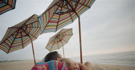 한 남자와 한 여자가 우산 아래 해변에 누워 있다 사진 Unsplash의 성인 이미지