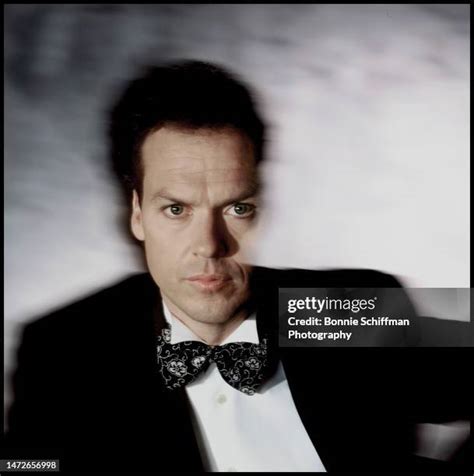 Actor Michael Keaton Faces Camera In A Suit And Bowtie Amidst Haze In