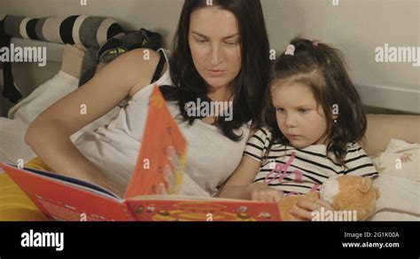 A Mother Reading Her Daughter A Book Before Bed Stock Video Footage Alamy