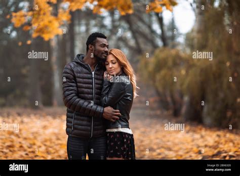 Interracial Couple Posing In Blurry Autumn Park Background Black Man