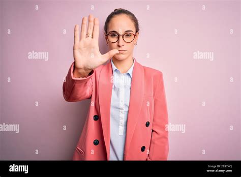 Young Beautiful Businesswoman Wearing Jacket And Glasses Over Isolated Pink Background Doing
