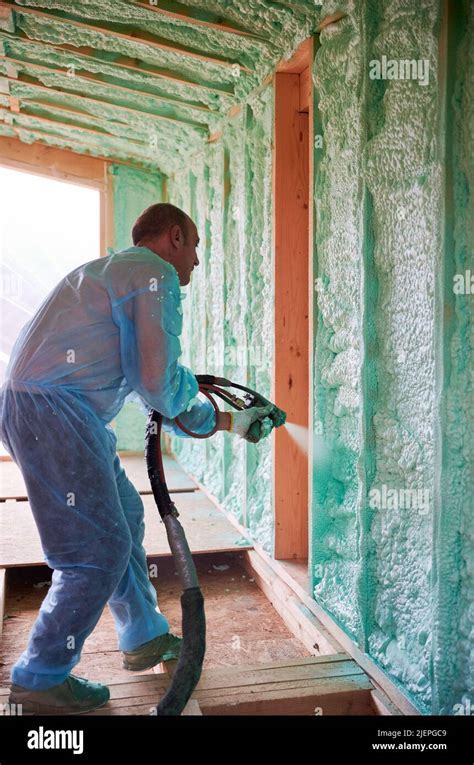 Male Builder Insulating Wooden Frame House Man Worker Spraying