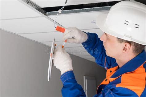 An Electrician Installing Lighting In A False Ceiling Side View Stock Image Image Of Electric