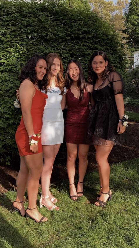 Four Women Are Standing Together In Front Of A Bush And Bushes Posing