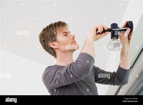 Man Installing Light Fixture In House Stock Photo Alamy