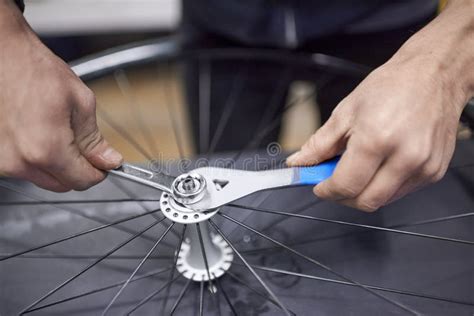 Man Assembling A Bike Wheel Axle After The Process Of Cleaning And