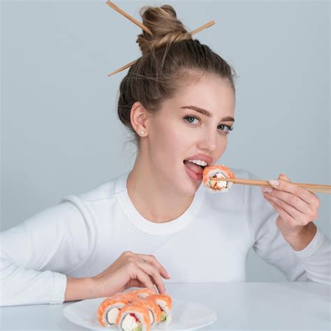 Mulher sexy estilo sushi japonês come rolos de sushi de comida