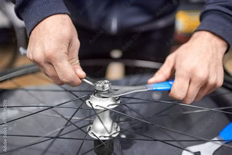Unrecognizable Person Assembling A Bike Wheel Axle After Disassembling It For Cleaning And