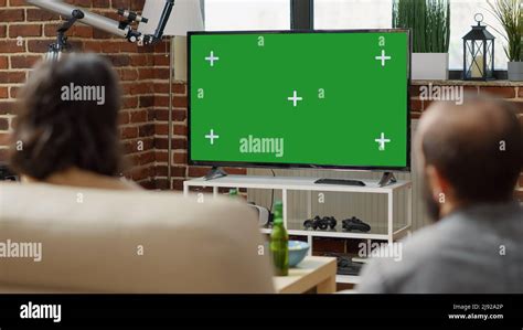 Man And Woman Watching Green Screen On Television Display In Living Room People Looking At