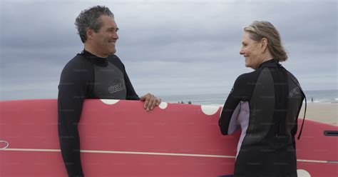 해변에서 서핑보드를 들고 있는 남자와 여자 사진 Unsplash의 바다 이미지