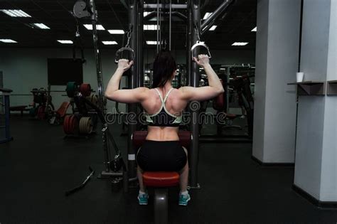 A Young And Beautiful Girl Trains Lifting A Load On The Simulator In A Young And Beautiful Girl Trains Lifting A Load On The Simulator In