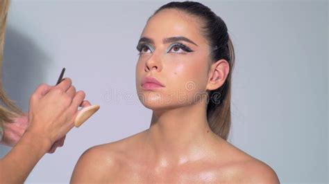 Makeup Artist Applying Tonal Foundation On The Face Of The Beauty Woman