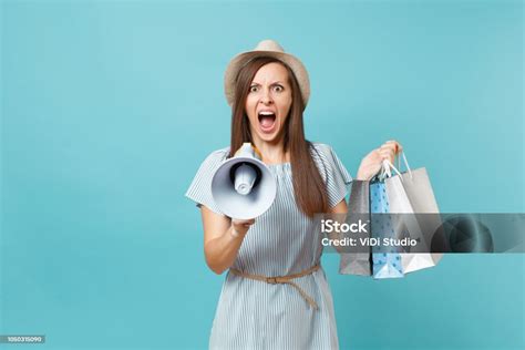 여름 드레스에 세로 여자 모자 패키지 가방을 들고 블루 파스텔 배경에 고립 된 할인 판매 발표 구매 후 쇼핑 확성기에서 비명 광고에 대 한 공간을 복사 합니다 가방에 대한