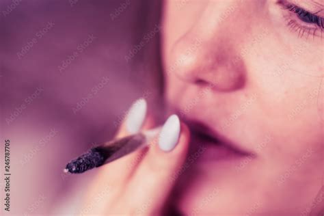 Joint In Woman Hand A Woman Smokes Cannabis Weed A Smoke On A Black
