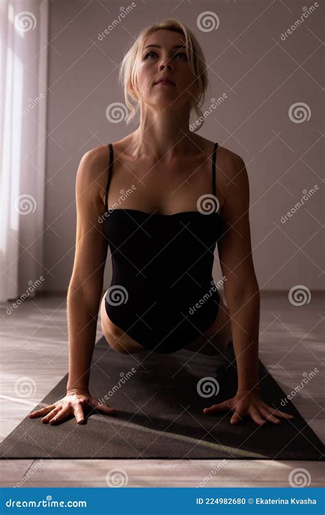 A Beautiful Blonde Girl In A Sports Swimsuit Is Engaged In Yoga
