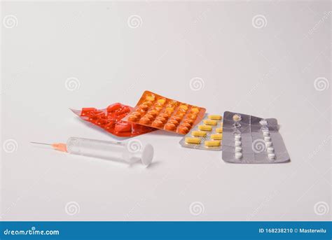 Multicolor Tablets And Pills Capsules From Glass Bottle On Blue