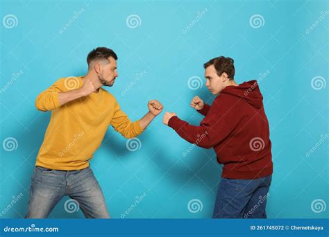 Dos Hombres Emotivos Peleando Con Fondo Azul Claro Foto De Archivo Imagen De Problema Maduro