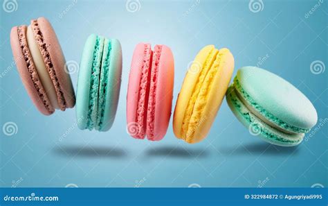 Different Types Of Macaroons In Motion Falling On Light Blue Background Sweet And Colorful