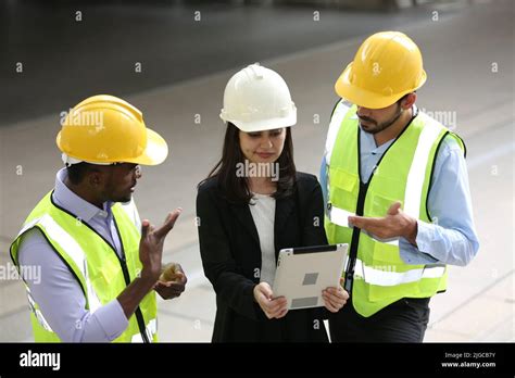 Architect Civil Engineer And Worker Looking At Plans And Blueprints
