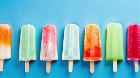 Colorful Popsicles Lined Up Against Vibrant Blue Background Showcasing Summery Frozen Treats