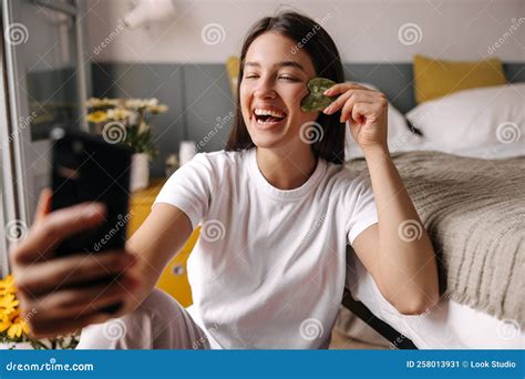 Attractive Young Caucasian Brunette Girl Massages Her Face And Laughs