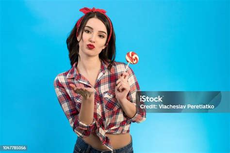 Wanita Cantik Dengan Permen Meniup Ciuman Udara Di Latar Belakang Biru