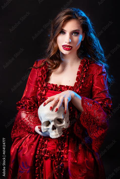 Portrait Of A Young Attractive Vampire Woman In A Red Dress In The