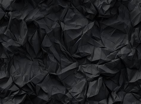 낮은 조명 배경에서 검은 구겨진 종이 매끄러운 질감 프리미엄 사진