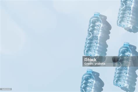 미니멀 패턴 플라스틱 병은 햇빛에 물을 주며 파란색에 그림자를 드리우고 미학적인 평면도를 보여줍니다 증류수 식수 오염 환경 보호 일회용 플라스틱을 줄이기 위한 에코 트렌드