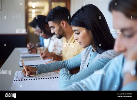 Students Writing Exam And Studying In Classroom For Education